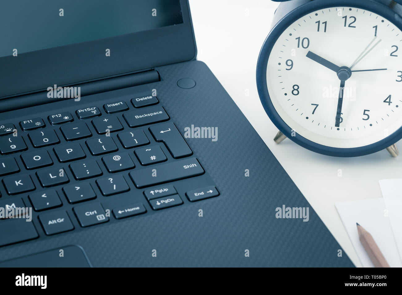 a work desk with a computer and office accessories and an alarm clock ...