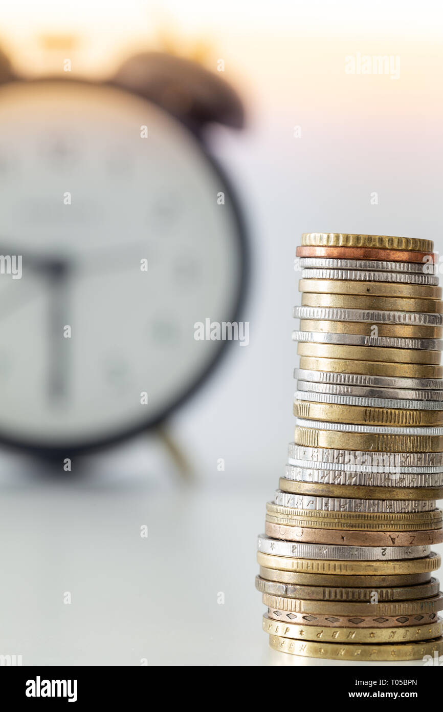 Clock on stack coins hi-res stock photography and images - Alamy