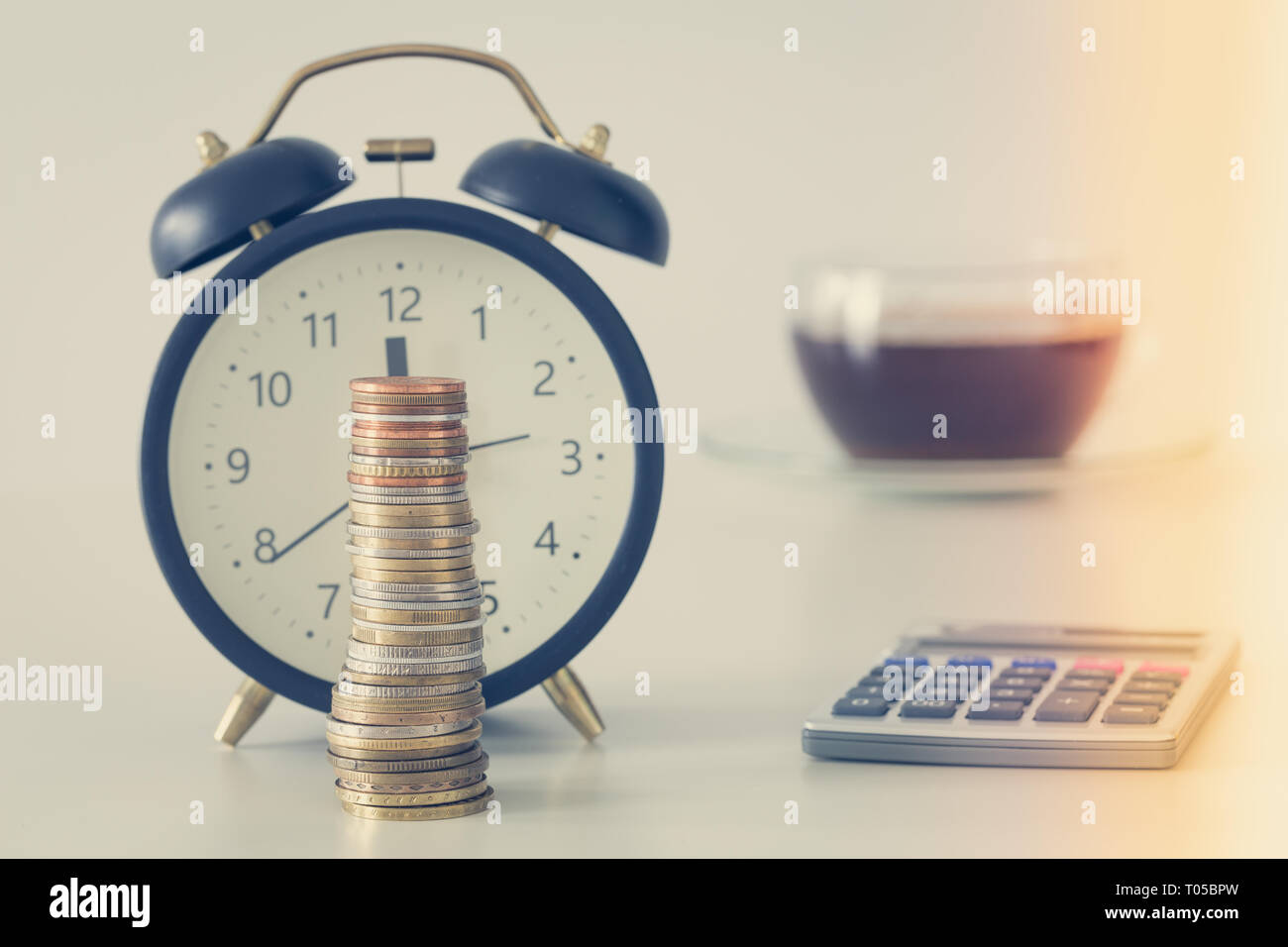 Clock on stack coins hi-res stock photography and images - Alamy