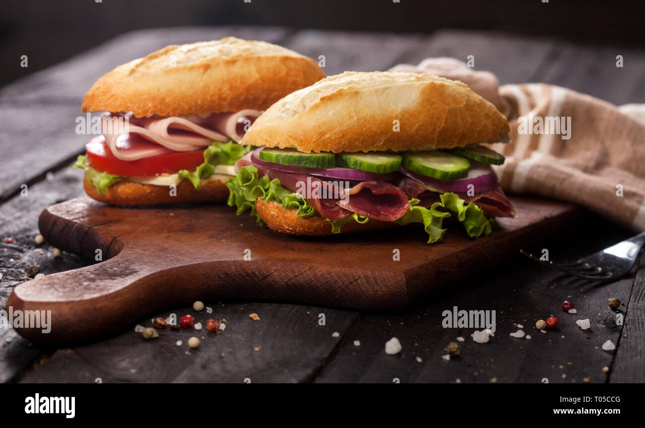 Fresh delicious burgers with cheese, tomato, onion, ham, prosciutto ...