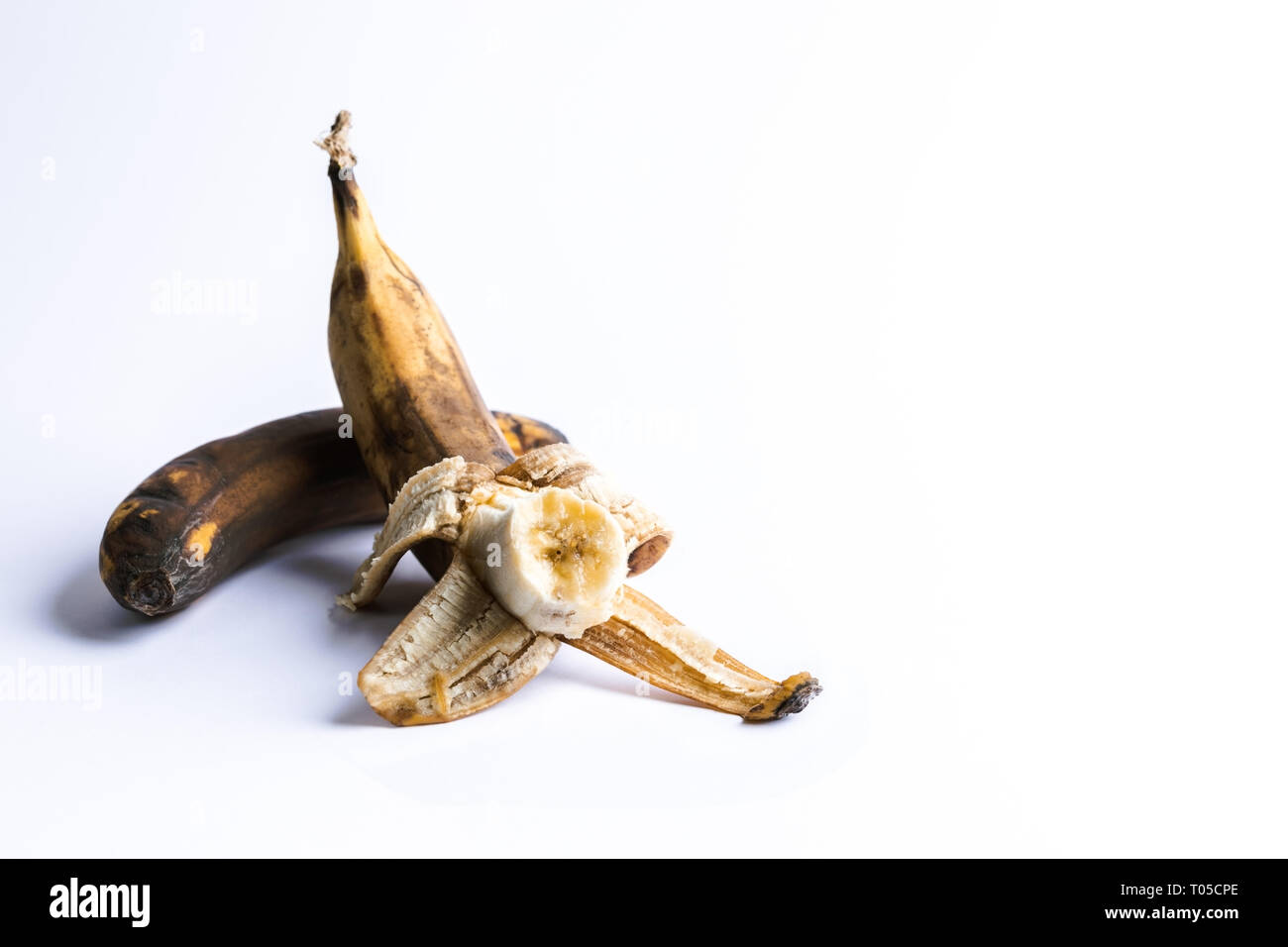 Two overripe blackened ugly bananas on white background Stock Photo - Alamy