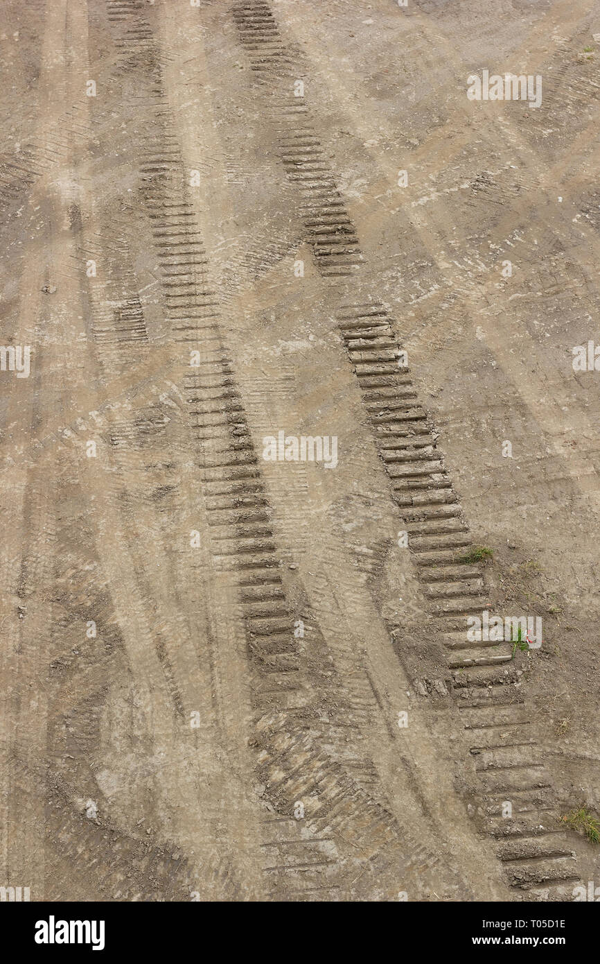 Tire tracks on a brown dirt road, textured imprints in different ...