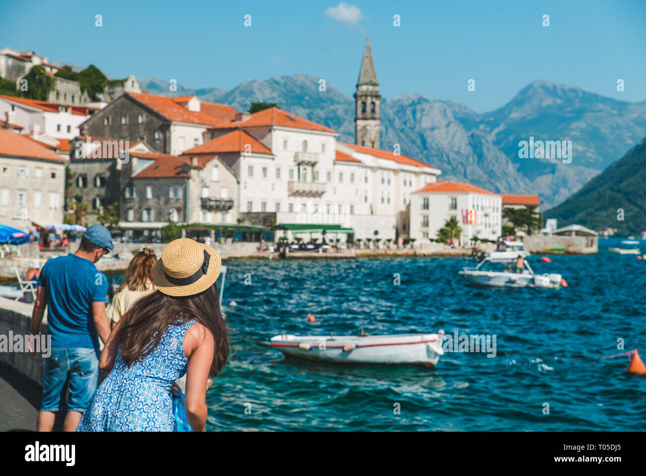 woman walking by Perast city. summer vacation. sea bay. mountains on ...