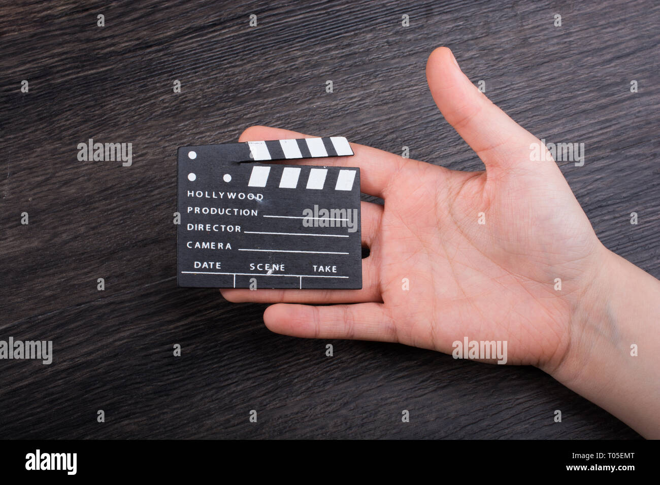 Hand holding movie clapper on a dark background Stock Photo - Alamy