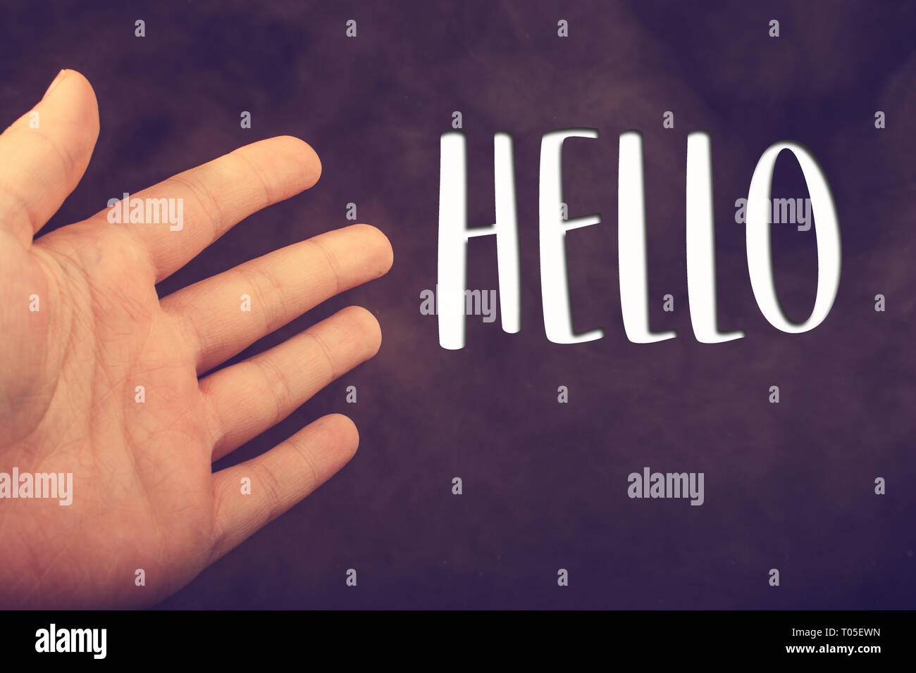 Hand making a hello welcome gesture on dark background Stock Photo - Alamy