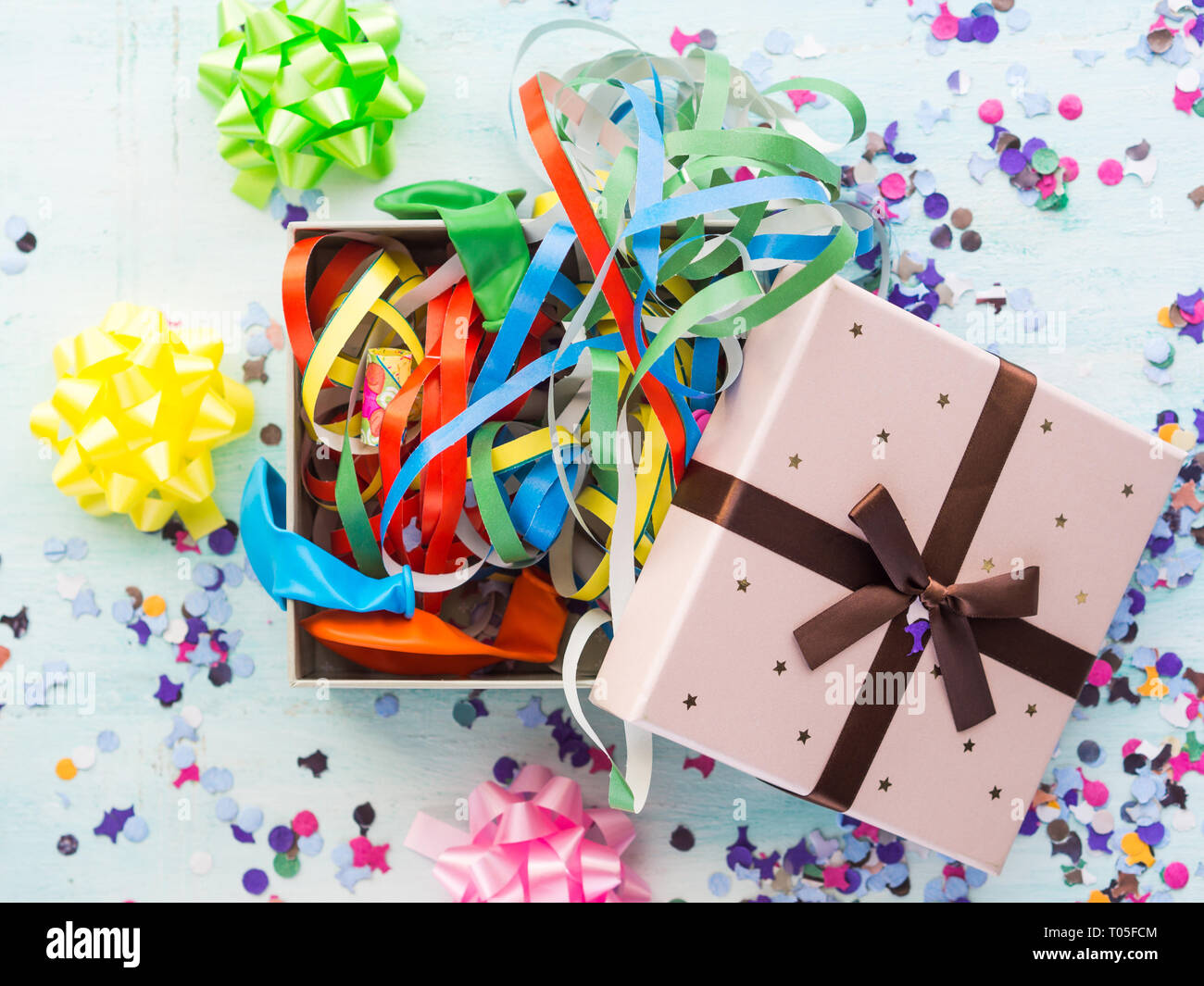 Open gift box with party streamers and confetti, bows. Bright colors ...
