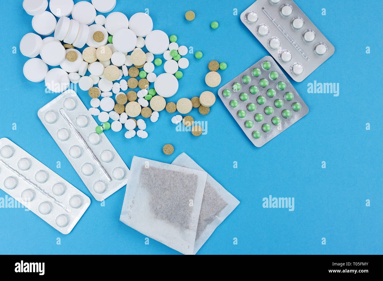 Assorted pharmaceutical medicine pills, tablets and capsules over blue ...