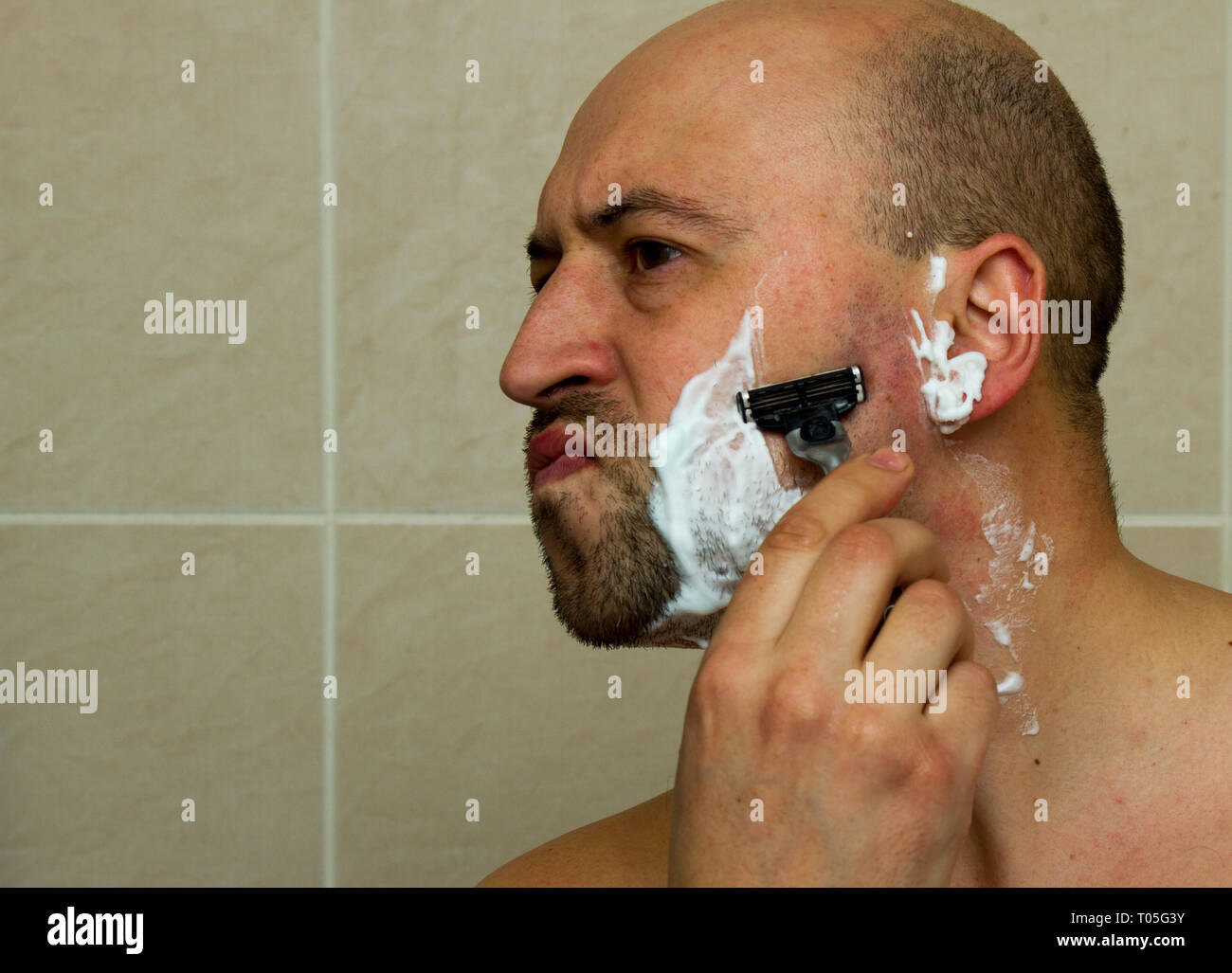 Man shaving his face with the razor blade through shave foam. Men skin ...