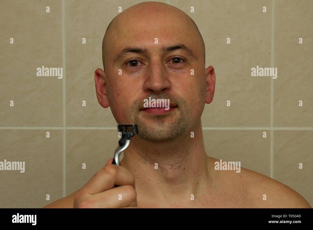 young guy with a razor in hand. Bald Stock Photo - Alamy