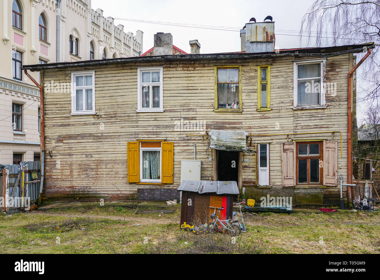 old poor two-storey wooden house in the city, childrens toys in the ...