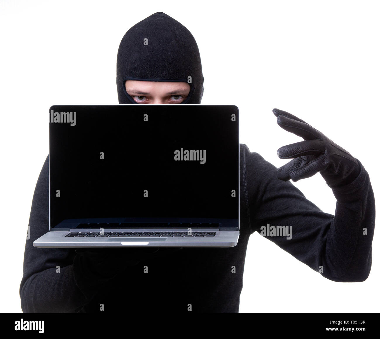 Hacker in black mask with laptop with blank screen in hands Stock Photo ...