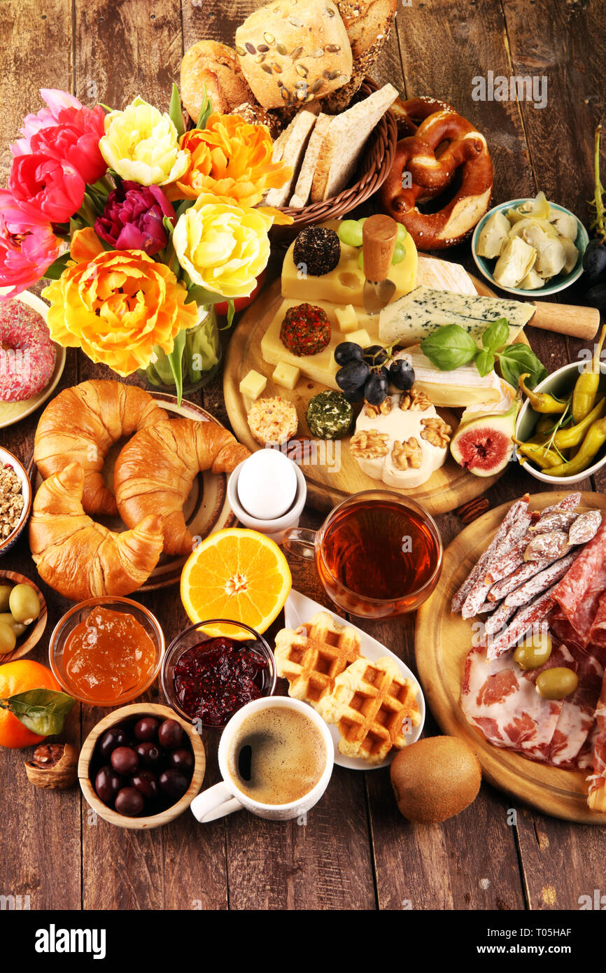 breakfast on table with bread buns, croissants, coffe and donuts Stock ...