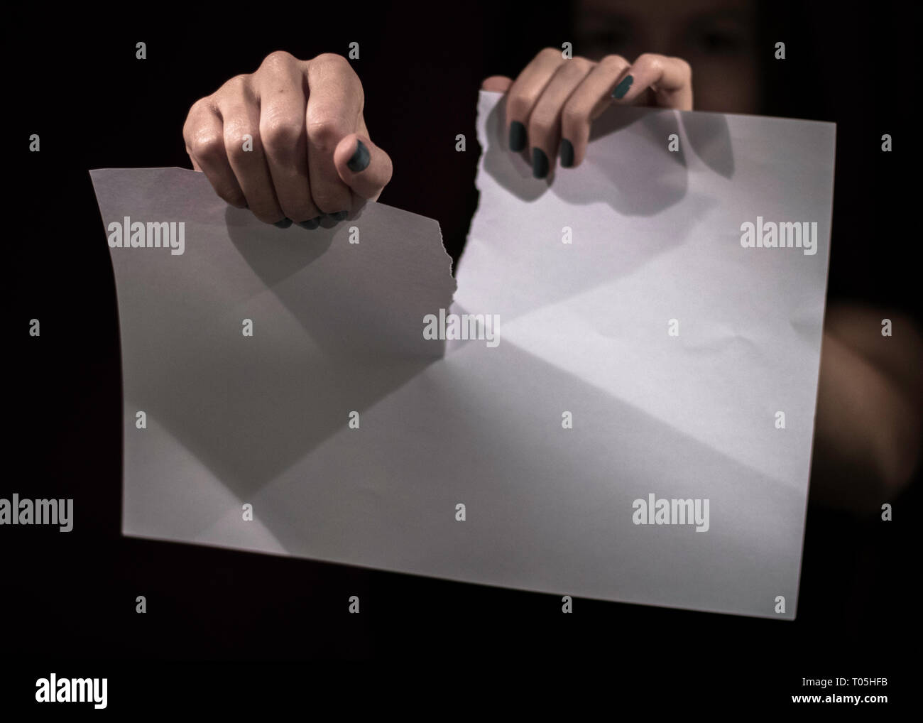 Women ripping appart white sheet of paper Stock Photo - Alamy