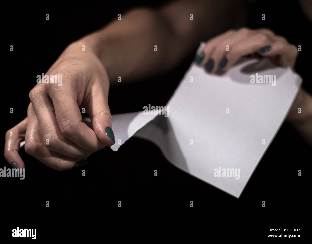 Women ripping appart white sheet of paper Stock Photo - Alamy