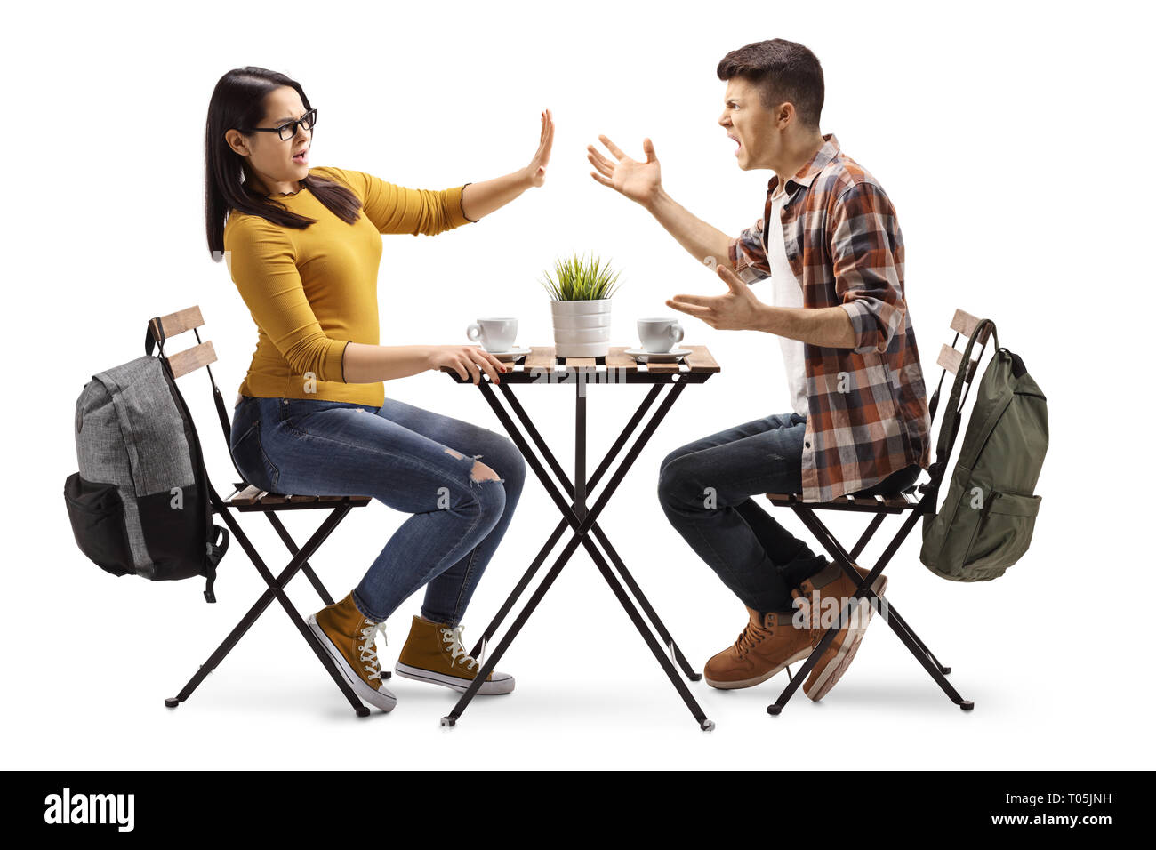 Full length profile shot of a male and female student arguing in a cafe ...