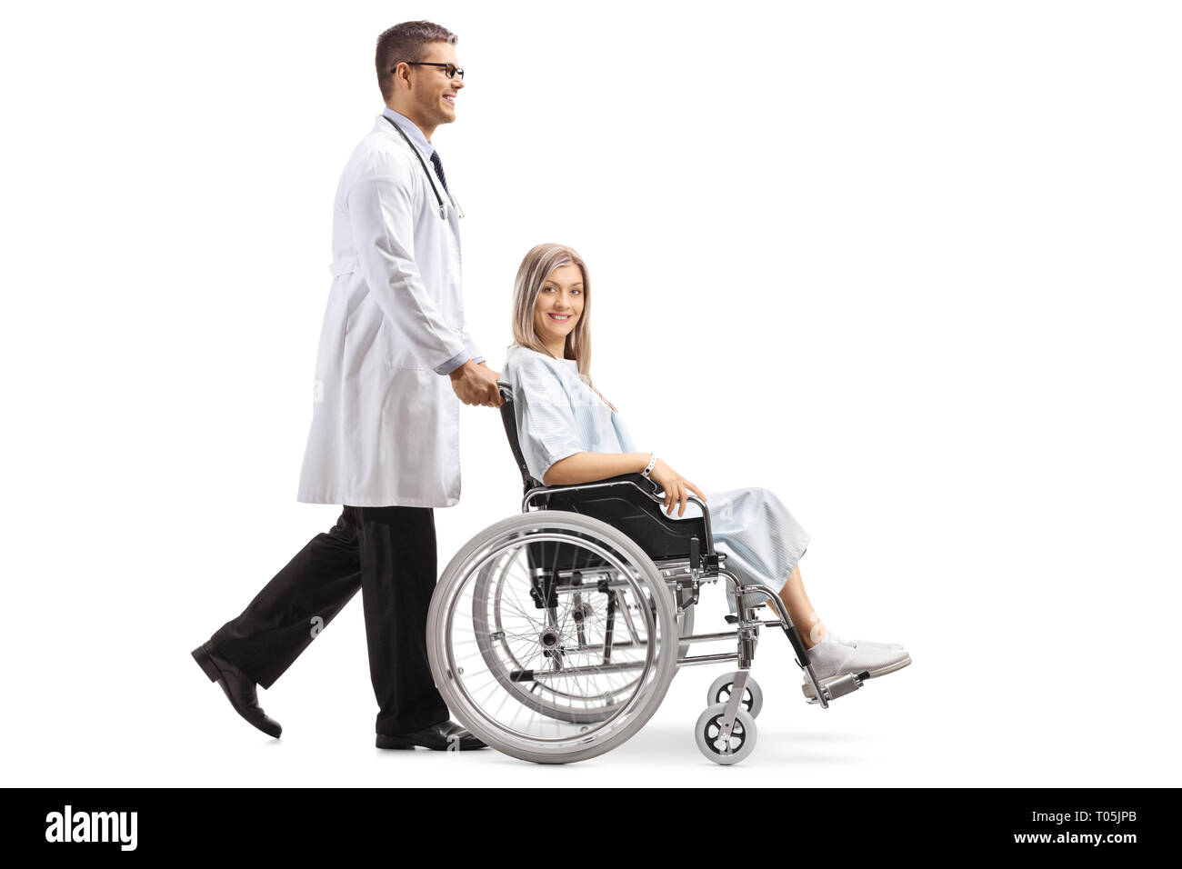 Full length shot of a young male doctor pushing a female patient in a ...