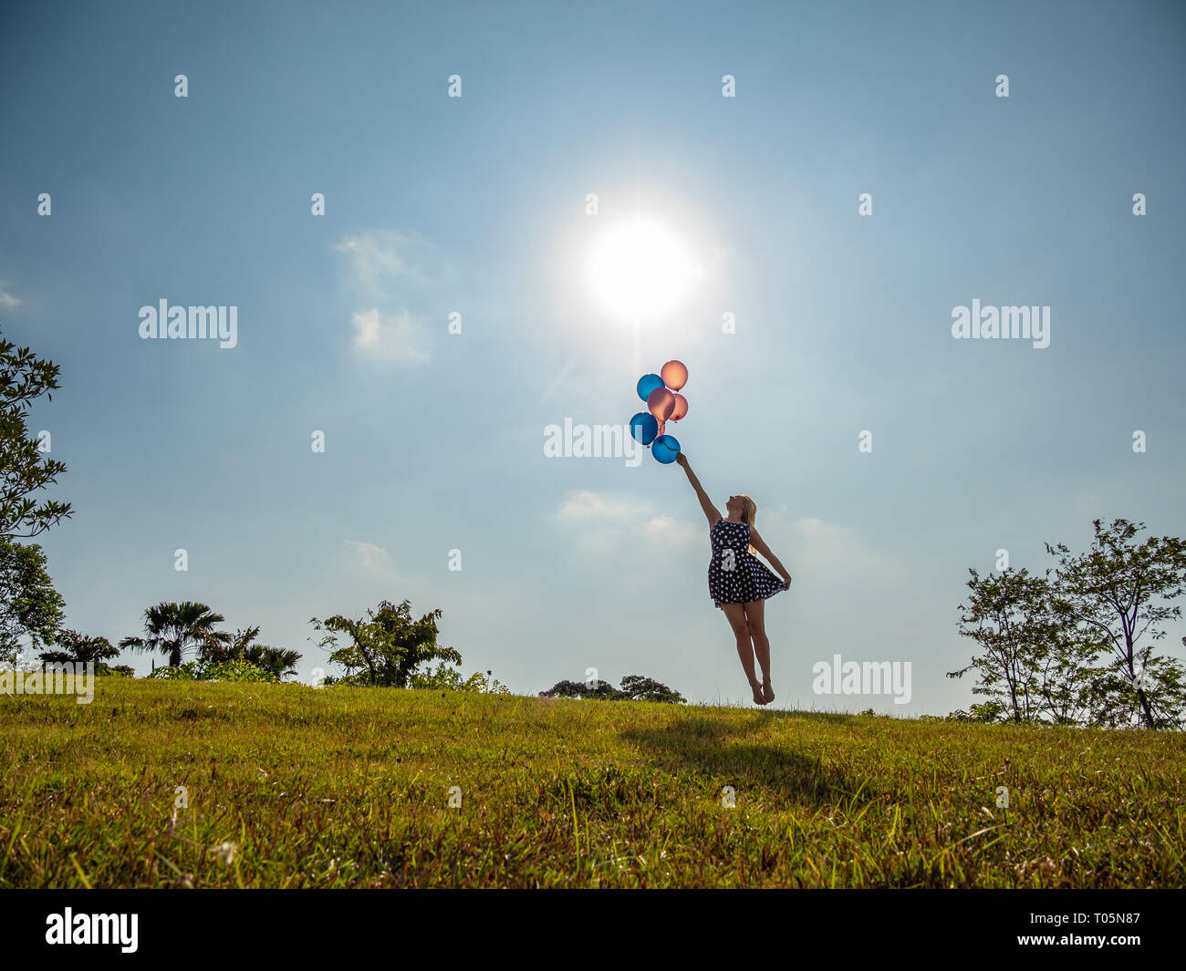 Female ballet dancer holding balloons flying away Stock Photo - Alamy