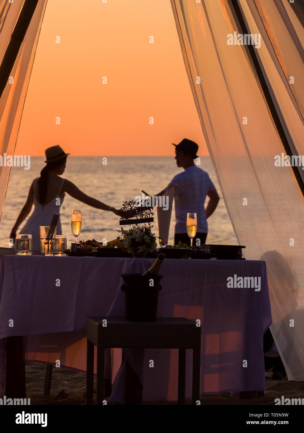 Dinner table for two at the beach at sunset Stock Photo - Alamy