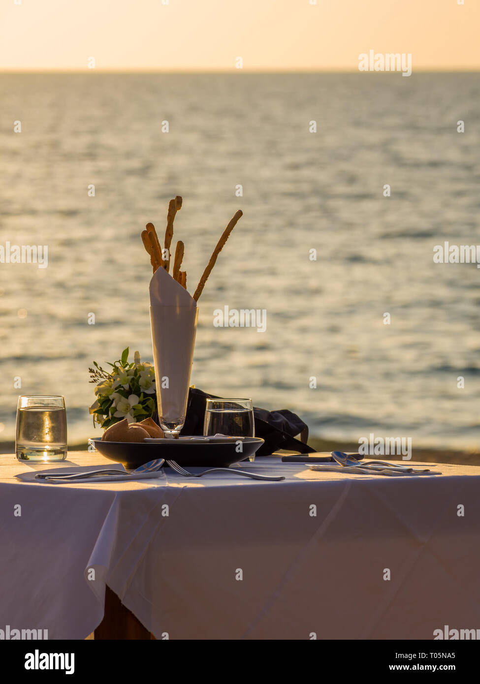 Dinner table for two at the beach at sunset Stock Photo - Alamy