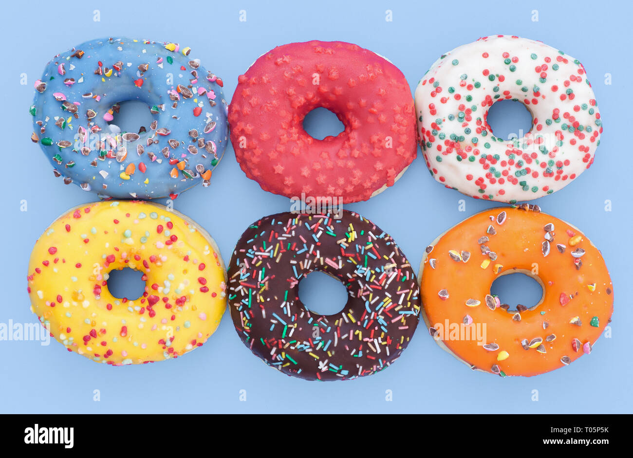 Set of donuts of various colors, blue background Stock Photo - Alamy