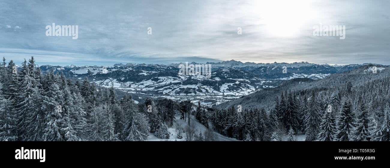 Stunning drone shots above a Snow covered forest landscape with views ...