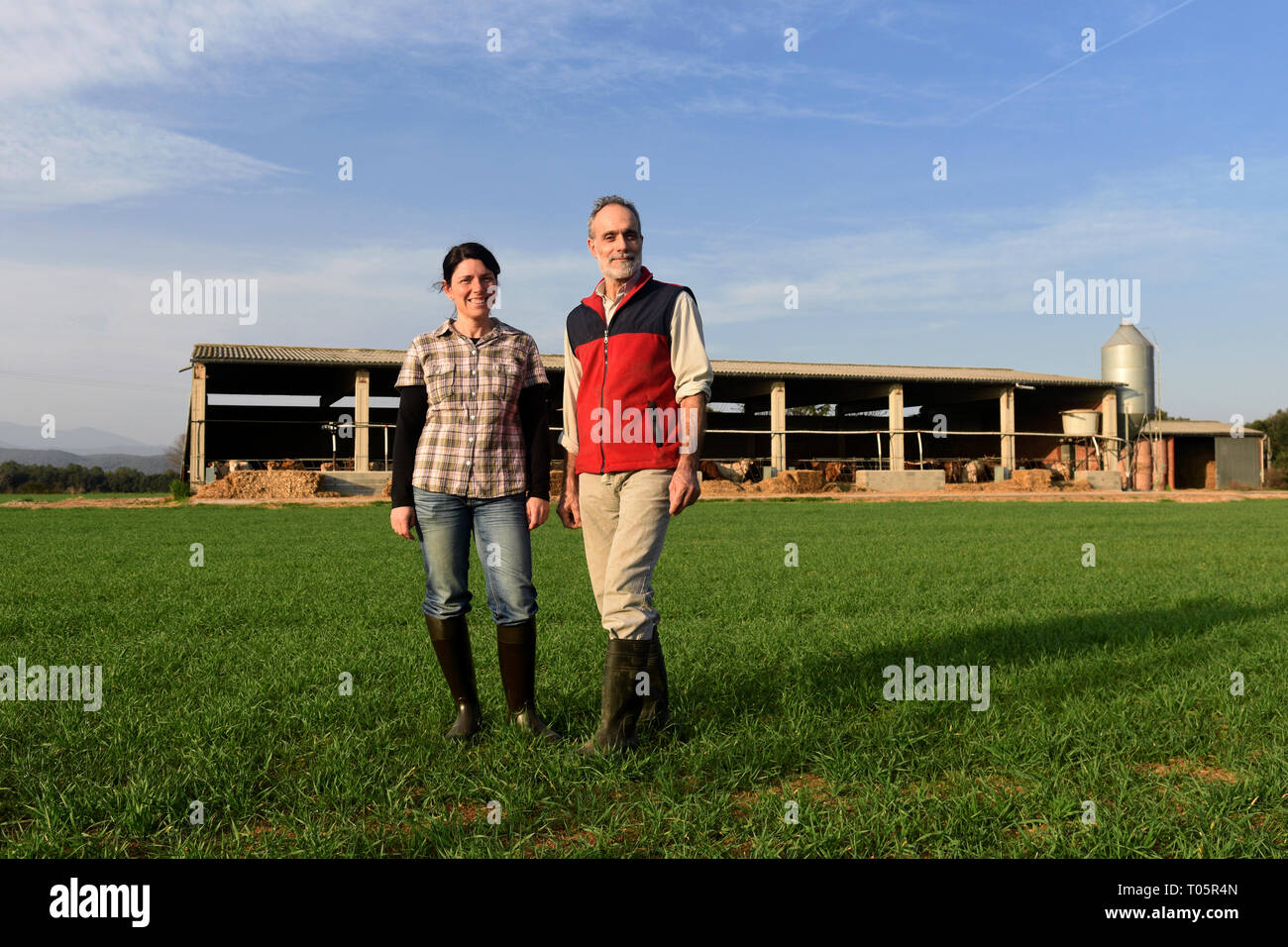Portrait of a couple farmer in the countryside with a farm at sunset ...