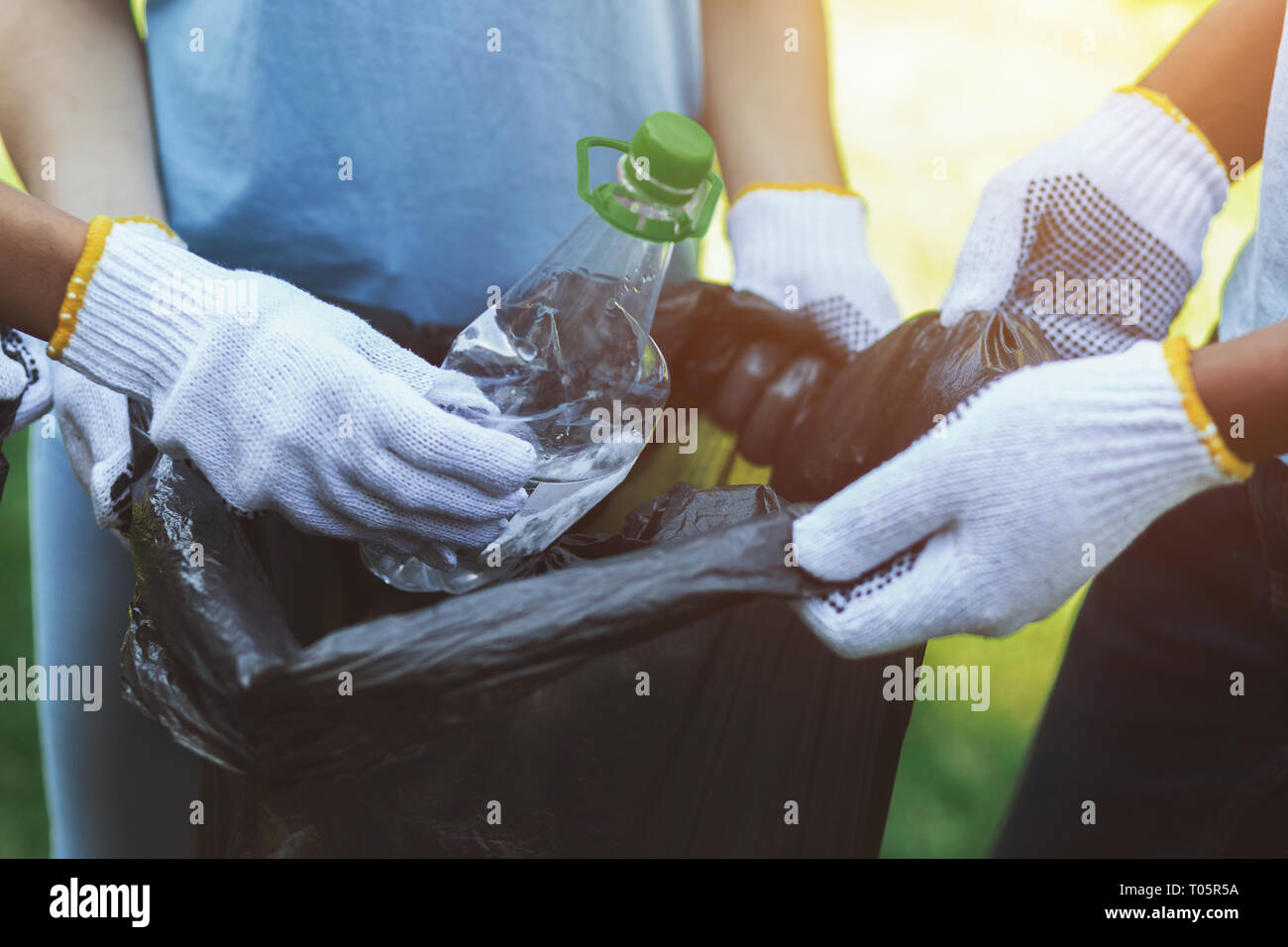 Volunteers collecting recyclable plastic bottles in park Stock Photo ...