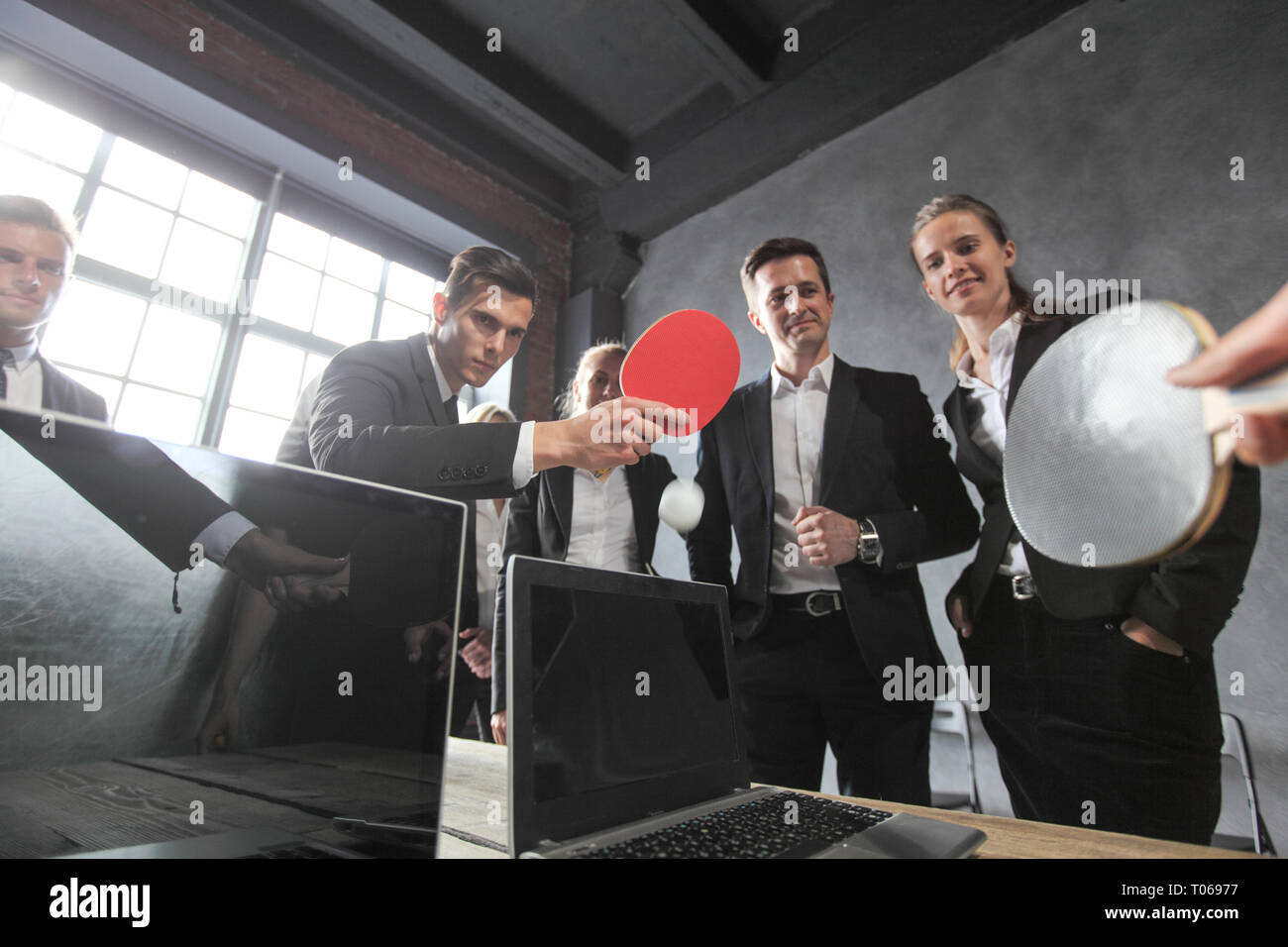 Business people play ping pong on office table with laptops Stock Photo ...