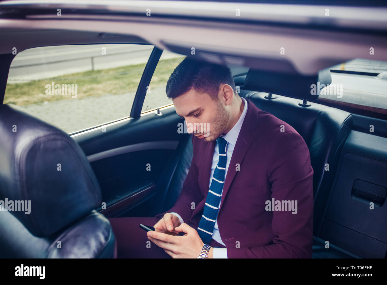 Businessman is going to a meeting and driving in the backseat of a ...