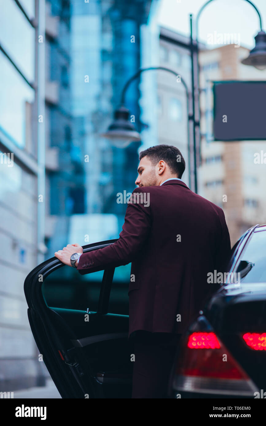 Handsome businessman entering and exiting his limo while looking sharp ...