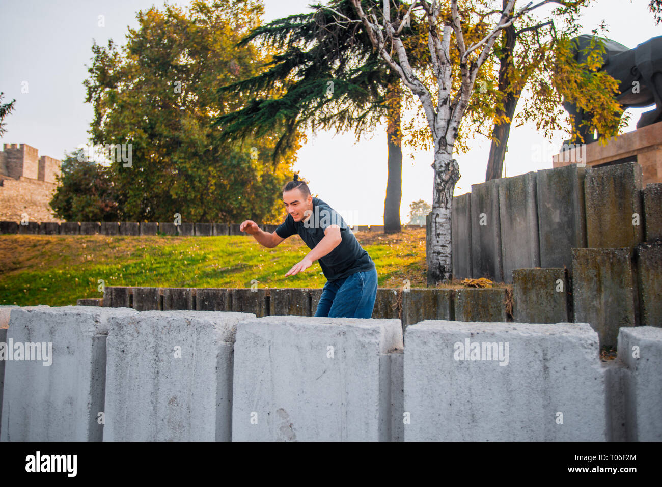 Free runner practicing jumping over obstacles in garden Stock Photo - Alamy
