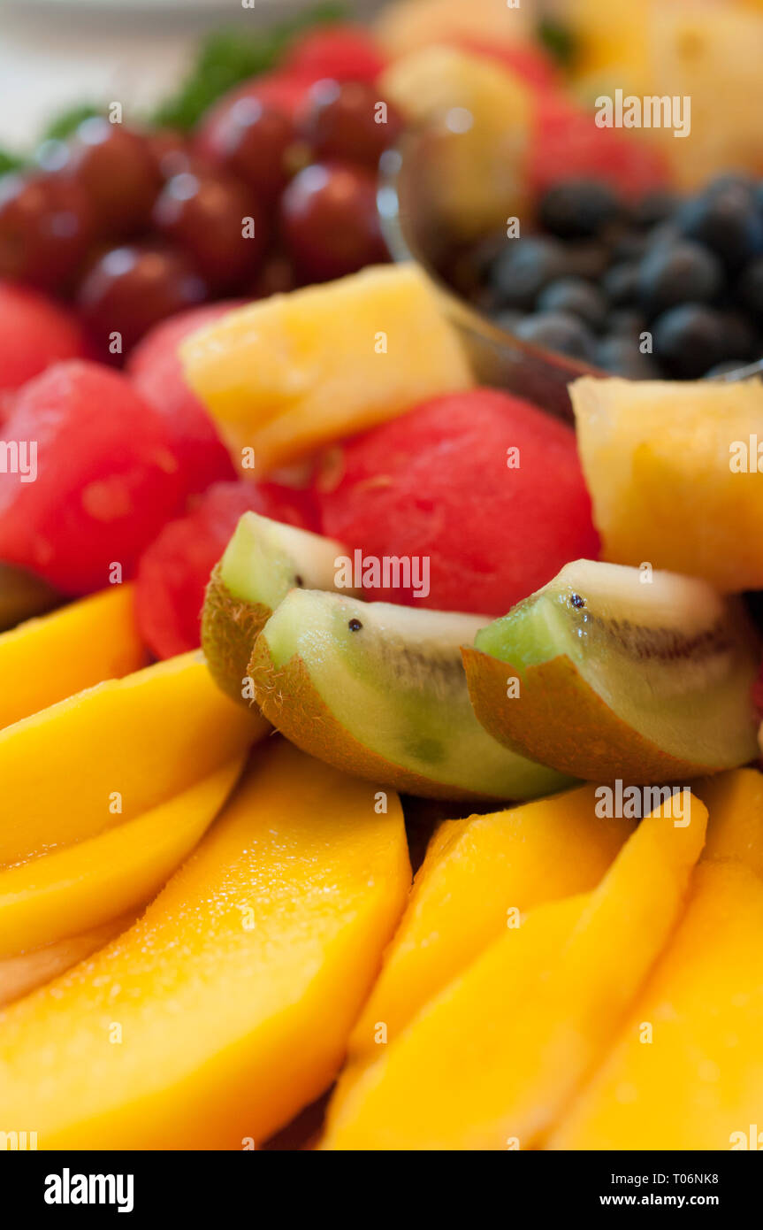 Fresh fruit arranged on a platter as slices, cubes, balls, and whole ...