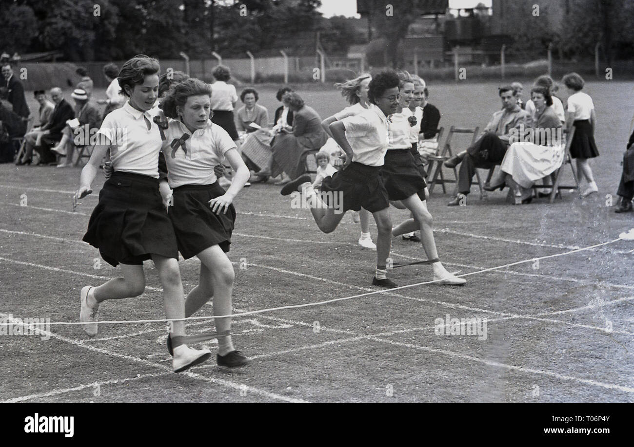 1950s, school sports, on a grass track, schoolgirls competing in the ...