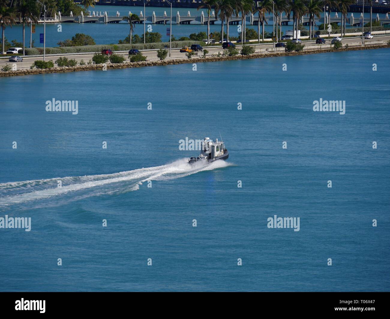 MIAMI, FLORIDA, USA —JANUARY 2018: A police boat creates ripples in the ...