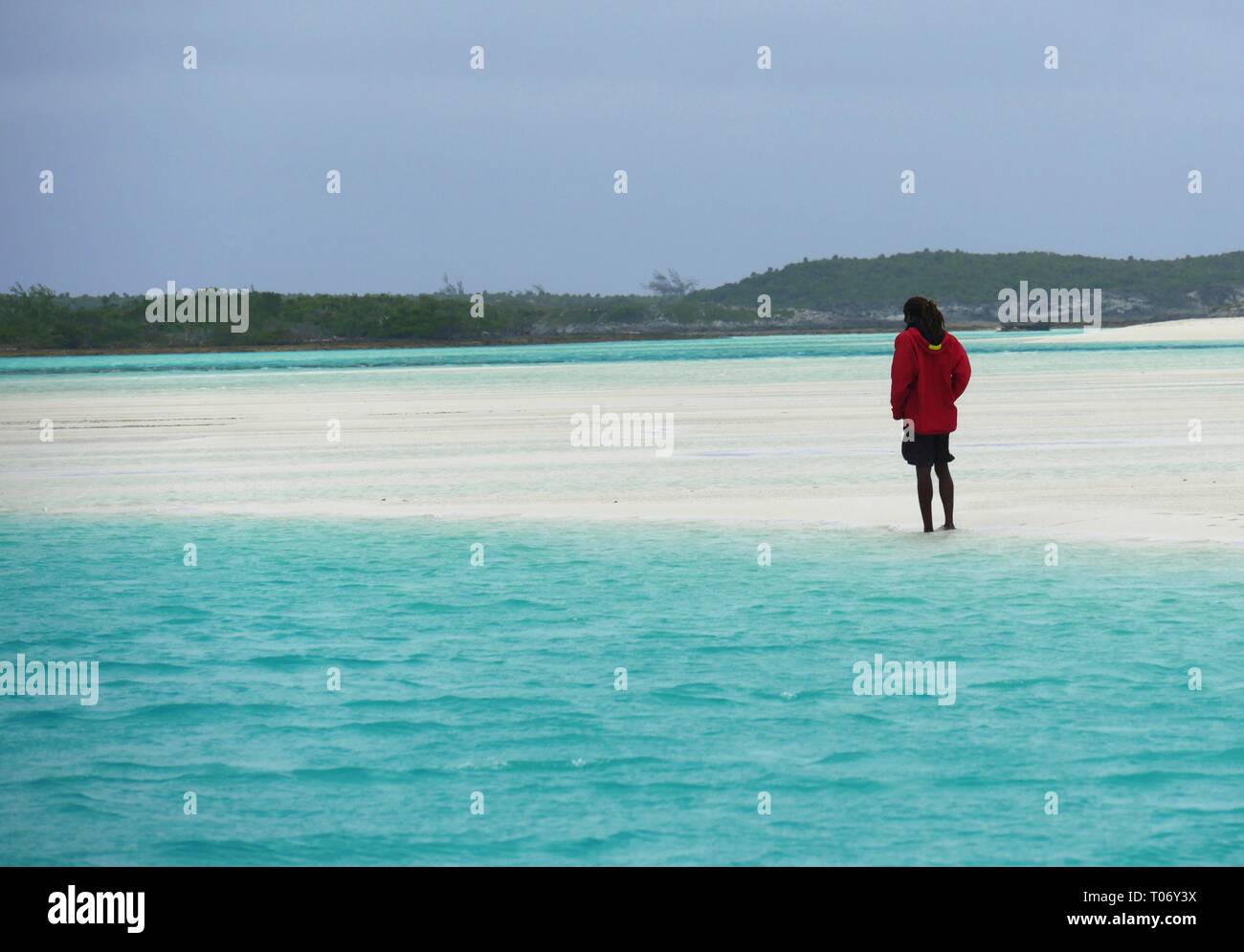 EXUMA CAYS, BAHAMAS—JANUARY 2018: A woman stands in the soft white ...