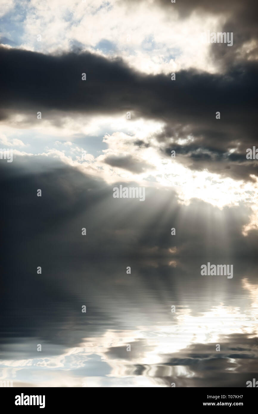 bright sun rays coming through the clouds and falling on sea water ...