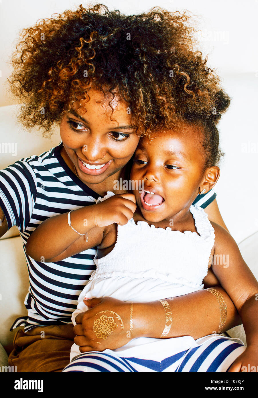 adorable sweet young afro-american mother with cute little daughter ...