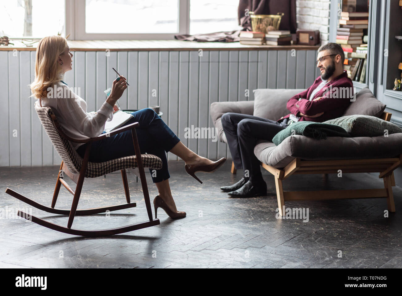 Psychologist wearing high-heeled shoes talking to her constant client ...