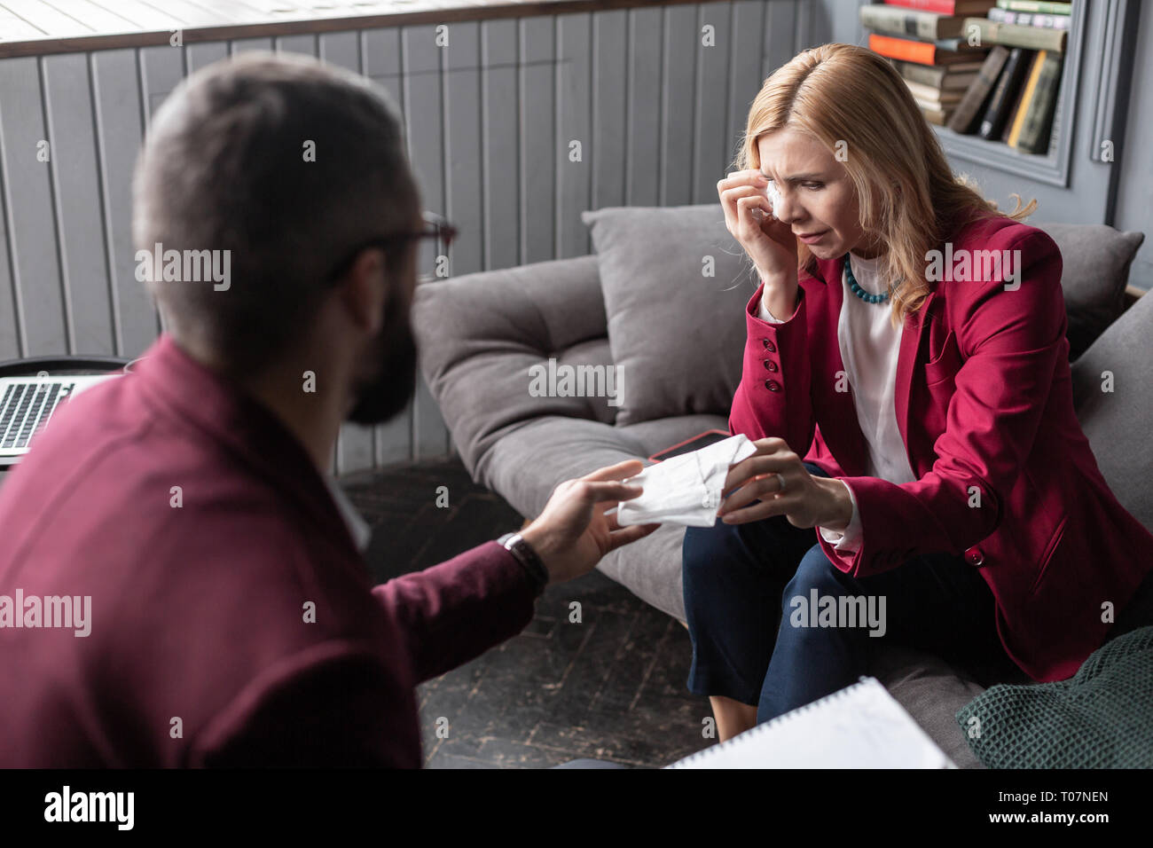 Helpful therapist giving napkin to client feeling emotional and crying ...