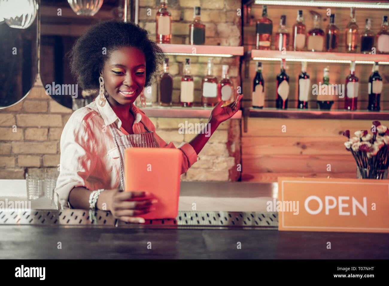 Alluring African-American bar employee making selfie standing at bar ...