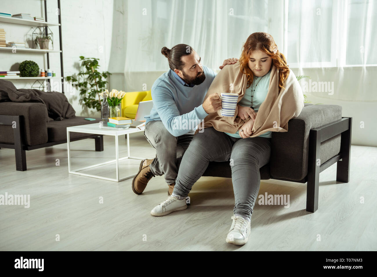 Upset young woman looking downwards at her hand Stock Photo - Alamy
