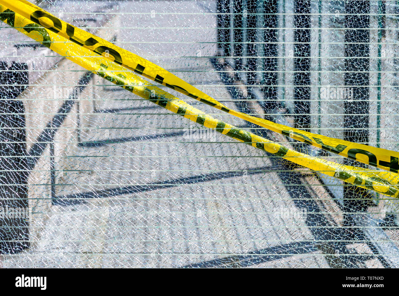 Broken and fractured Georgian wired glass panel with yellow caution ...