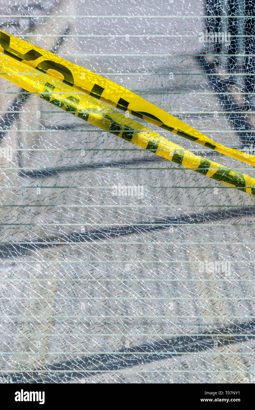 Broken and fractured Georgian wired glass panel with yellow caution ...