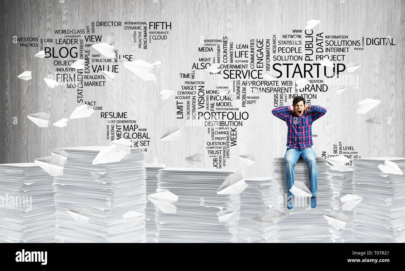 Attractive man sitting on pile of paper documents Stock Photo - Alamy