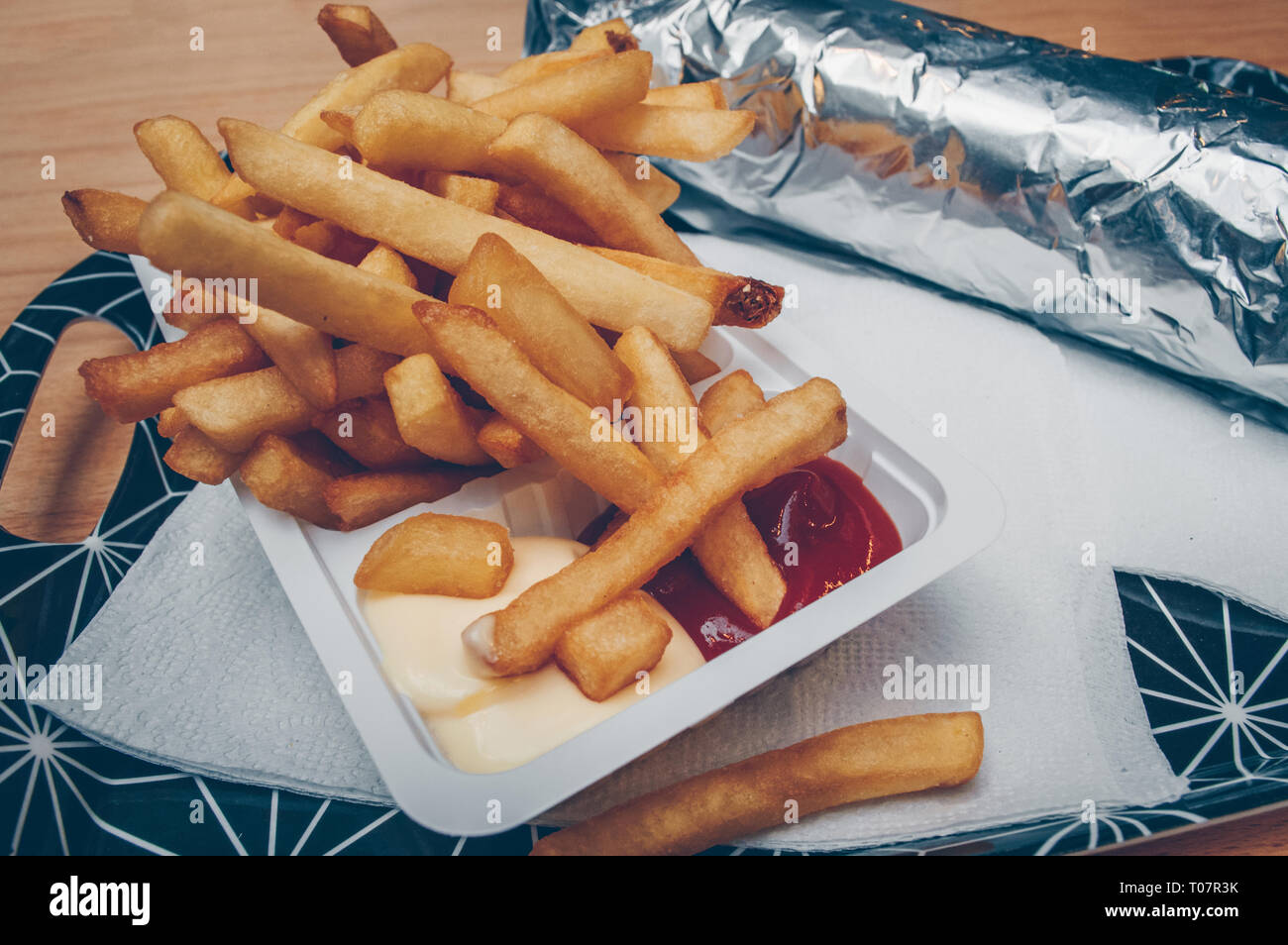 close up view of freshly made hot fries on a tray with napkins Stock ...