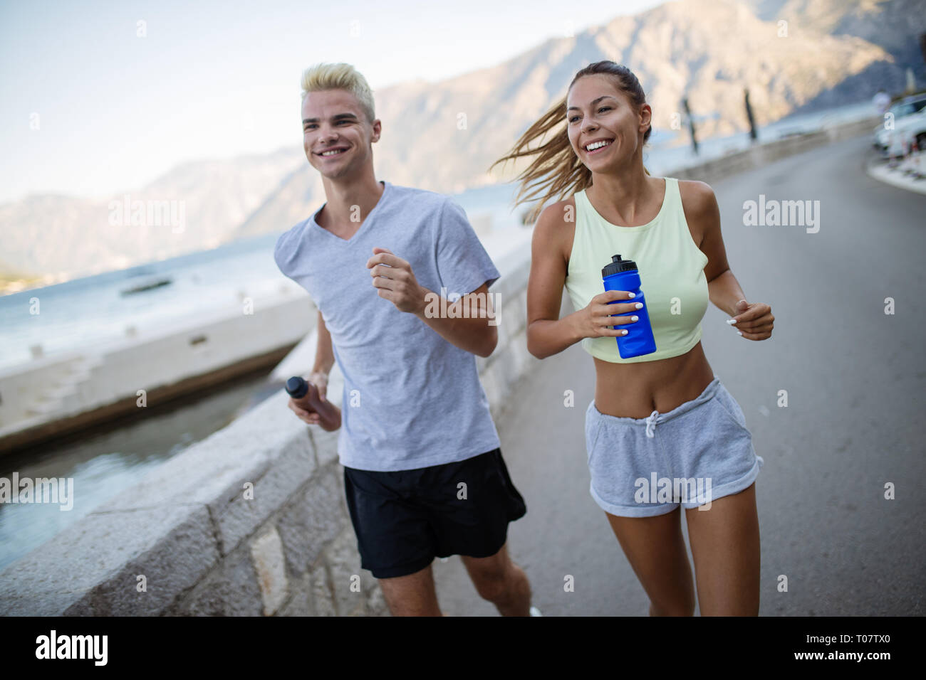 Happy fit people running and jogging together in summer sunny nature ...