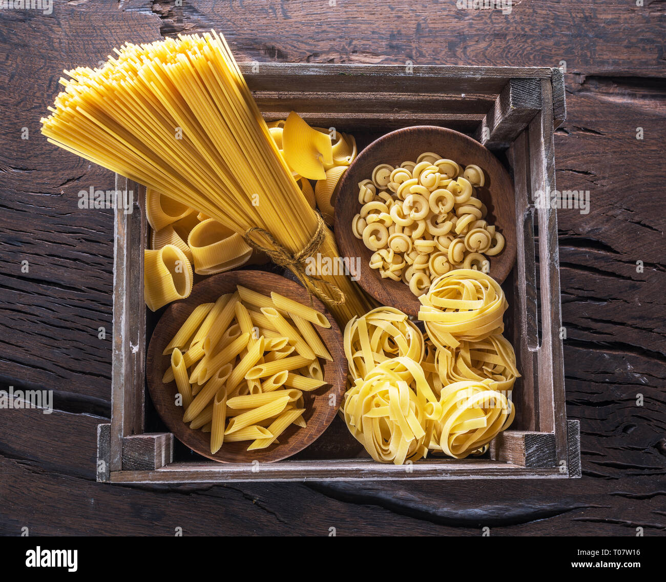 Different pasta types on the wooden table. Top view Stock Photo - Alamy