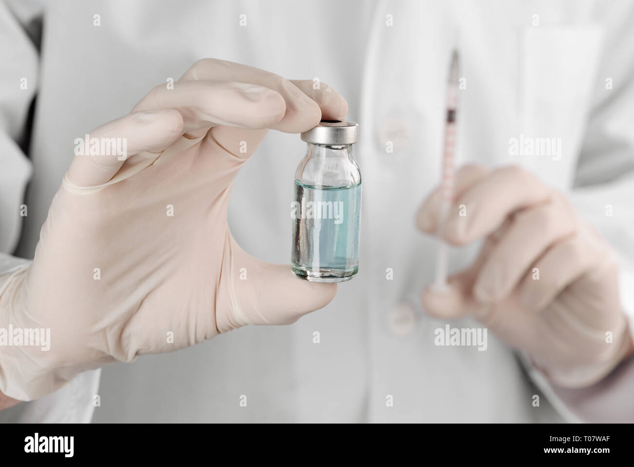 Doctor holding injection vial Stock Photo - Alamy