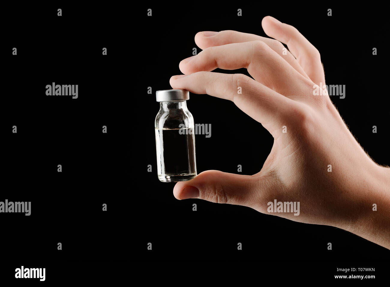 Hand holding a vial Stock Photo - Alamy