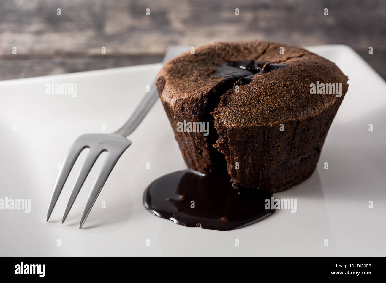 Coulant chocolate cake on wooden table Stock Photo - Alamy